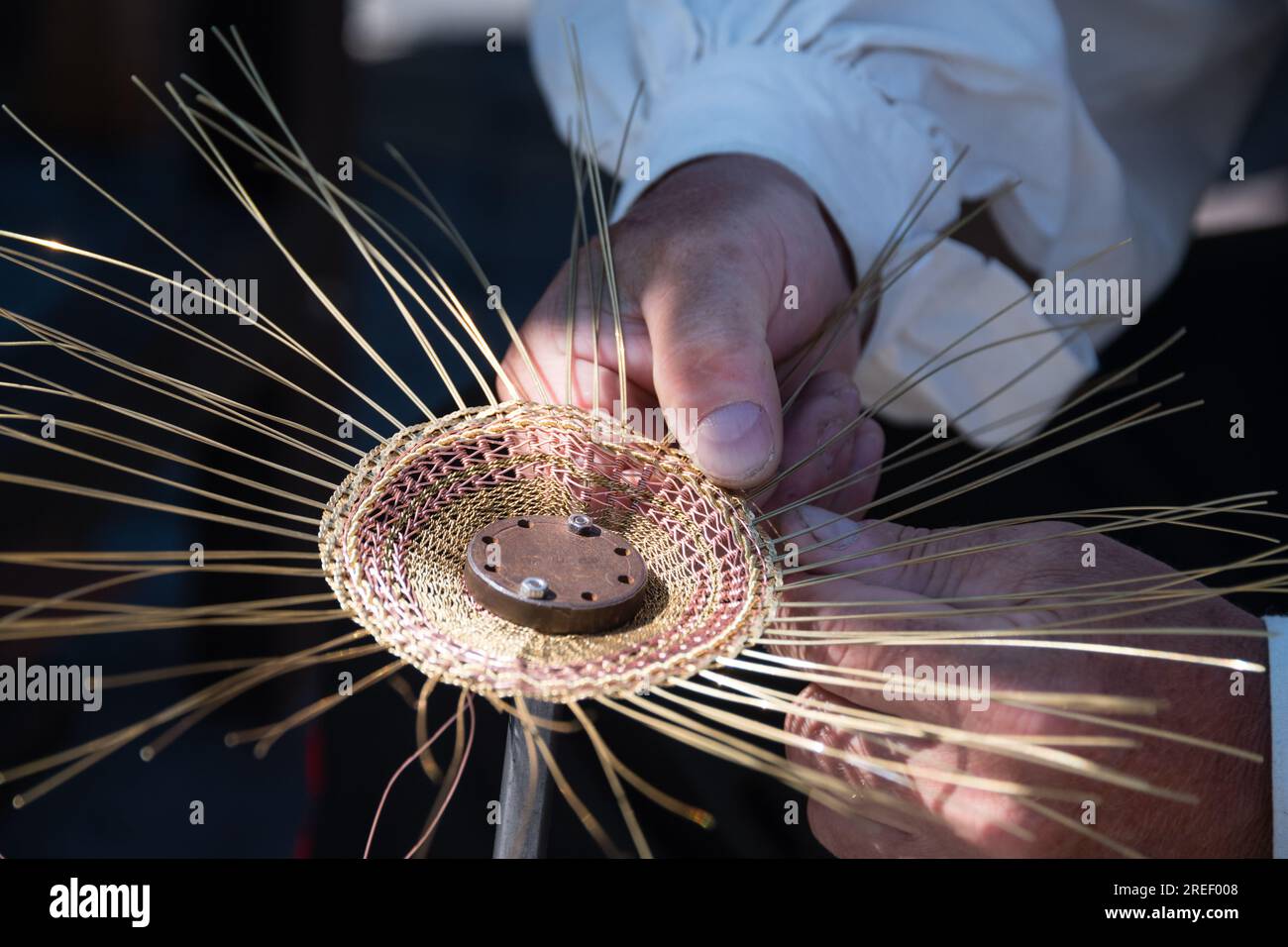 Hands of tinker making a product from wire. Traditional folk art in ...