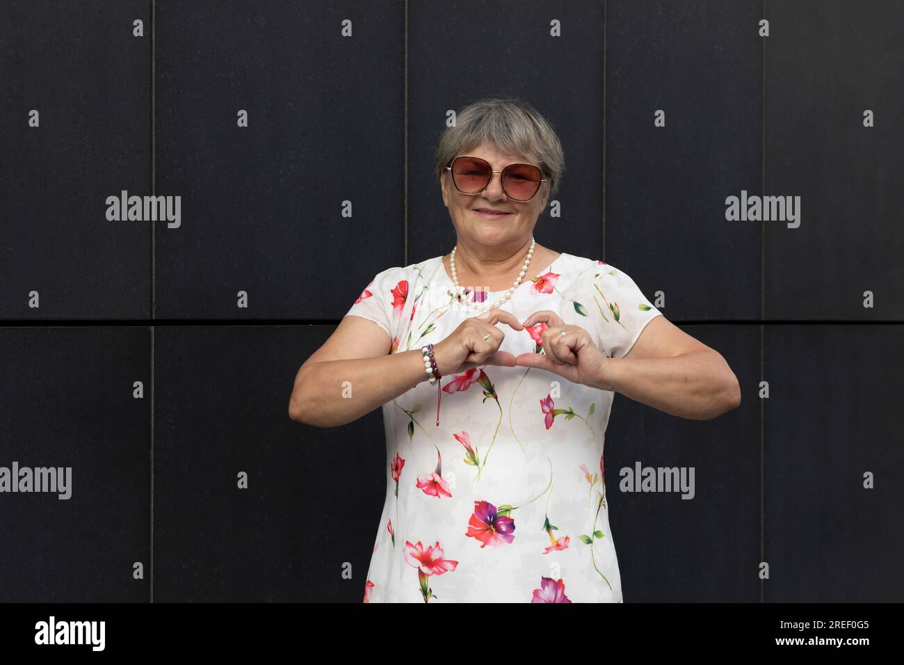 Smiling senior woman makes heart hi-res stock photography and images ...