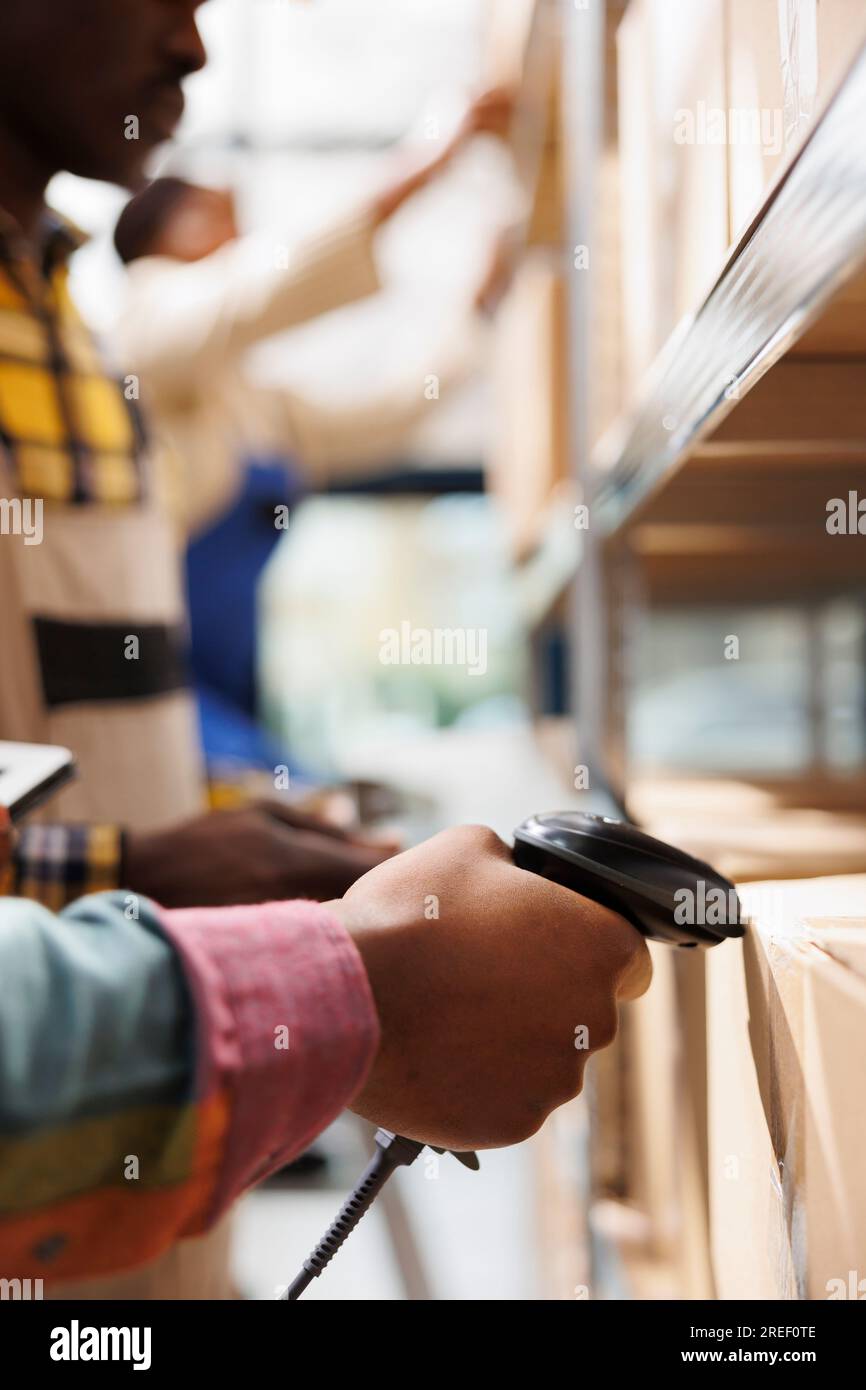 African american postal worker hand scanning parcel barcode in ...