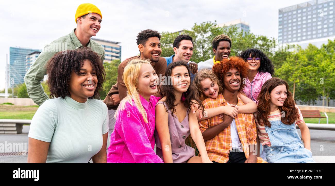Happy playful multiethnic group of young friends bonding outdoors ...