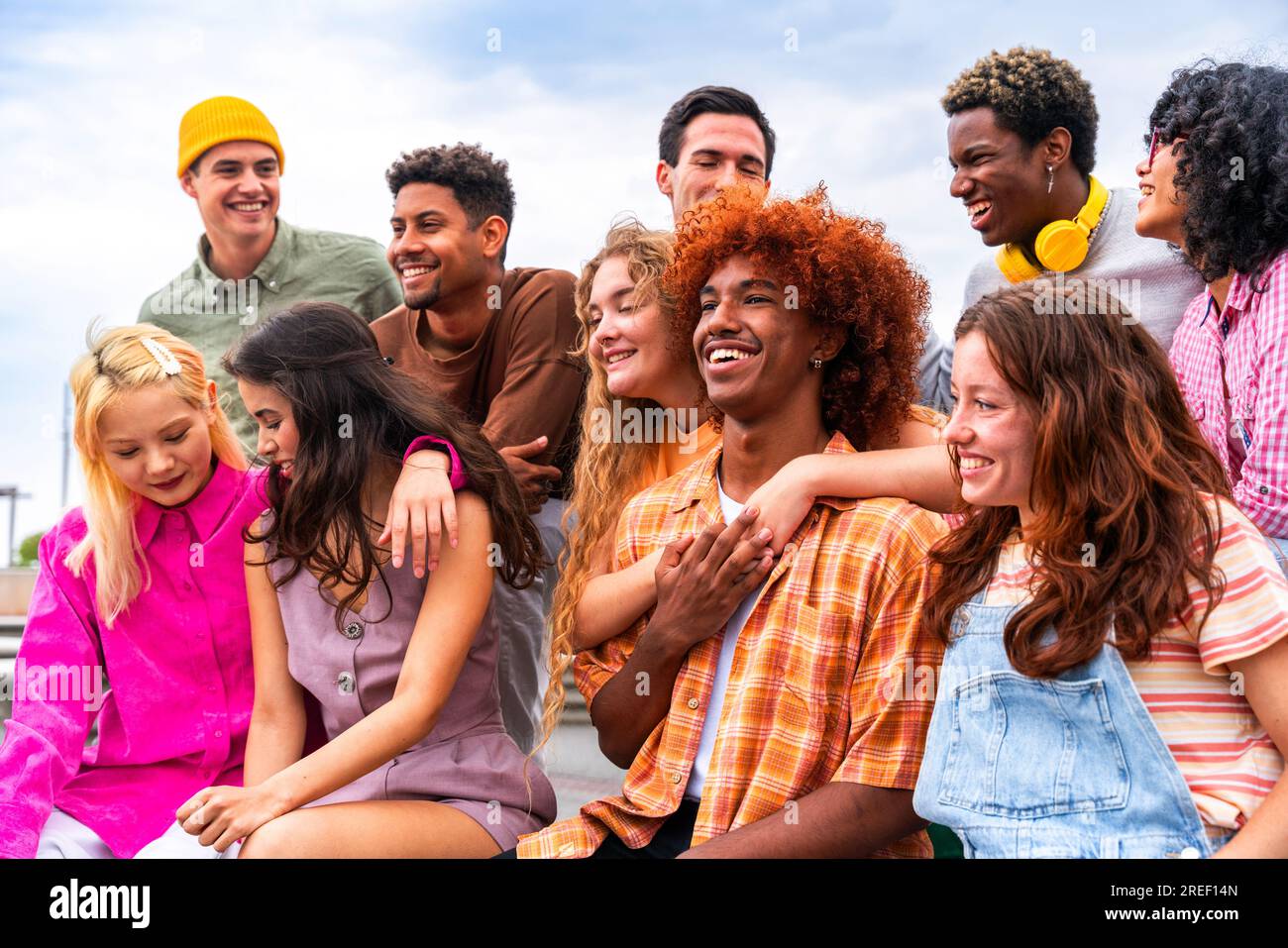 Happy playful multiethnic group of young friends bonding outdoors ...