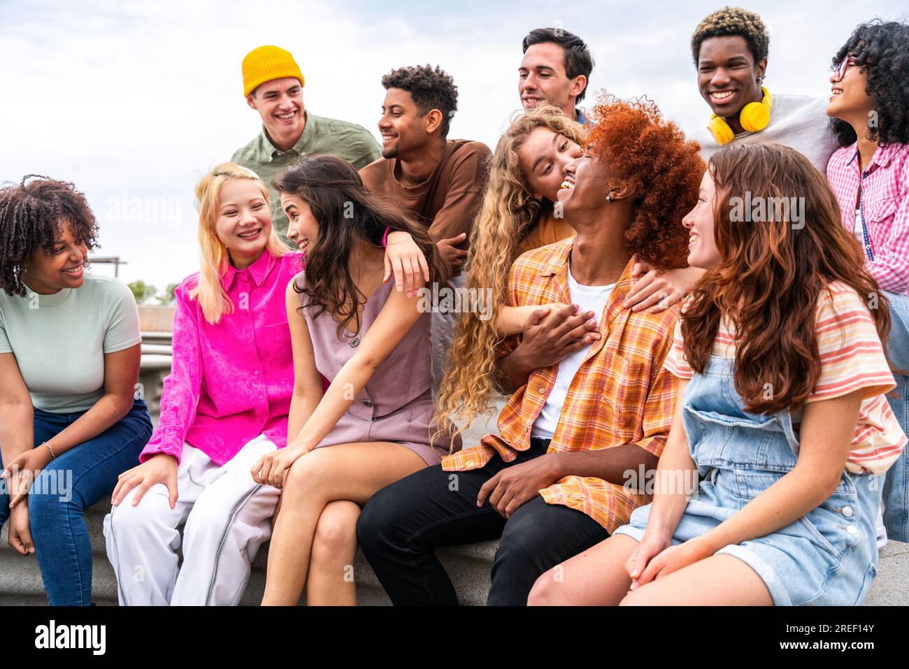 Happy playful multiethnic group of young friends bonding outdoors ...