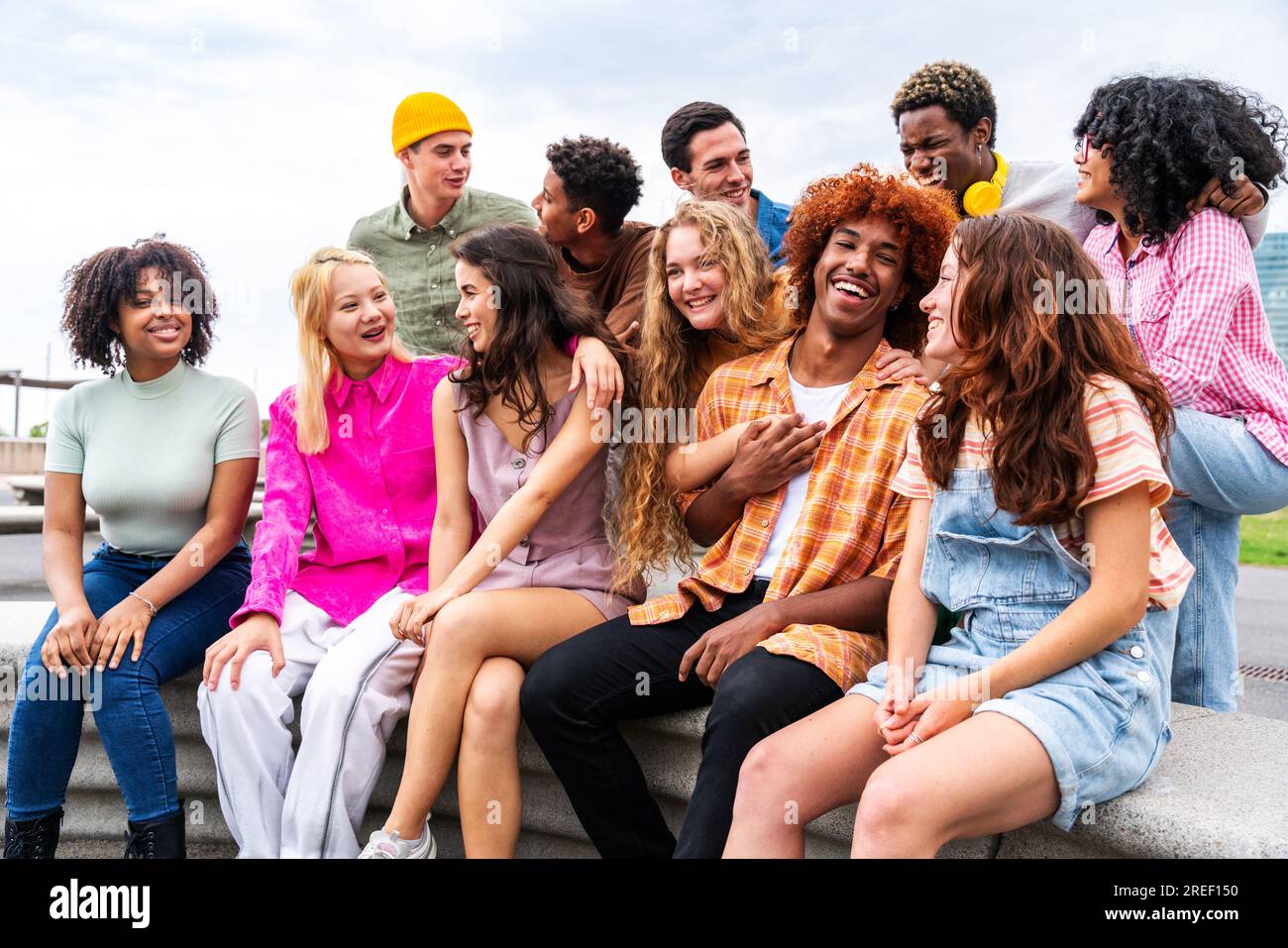 Happy playful multiethnic group of young friends bonding outdoors ...