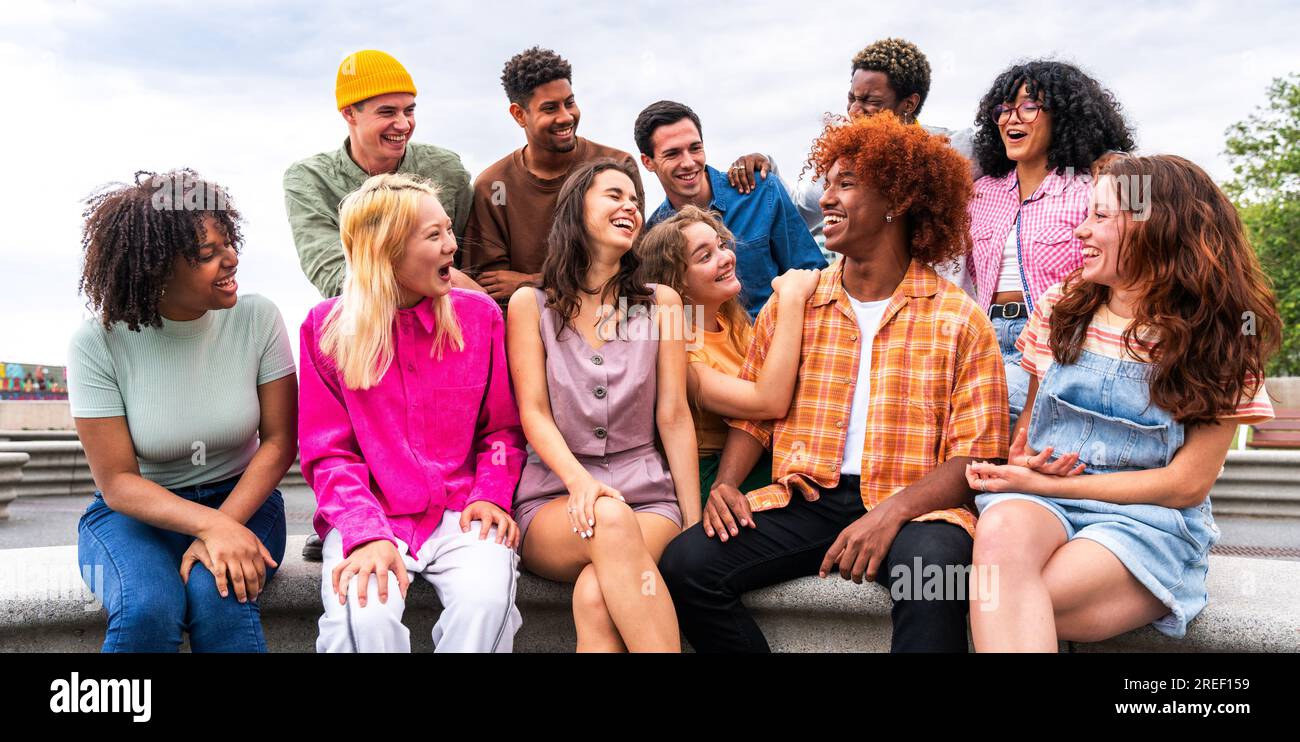 Happy playful multiethnic group of young friends bonding outdoors ...