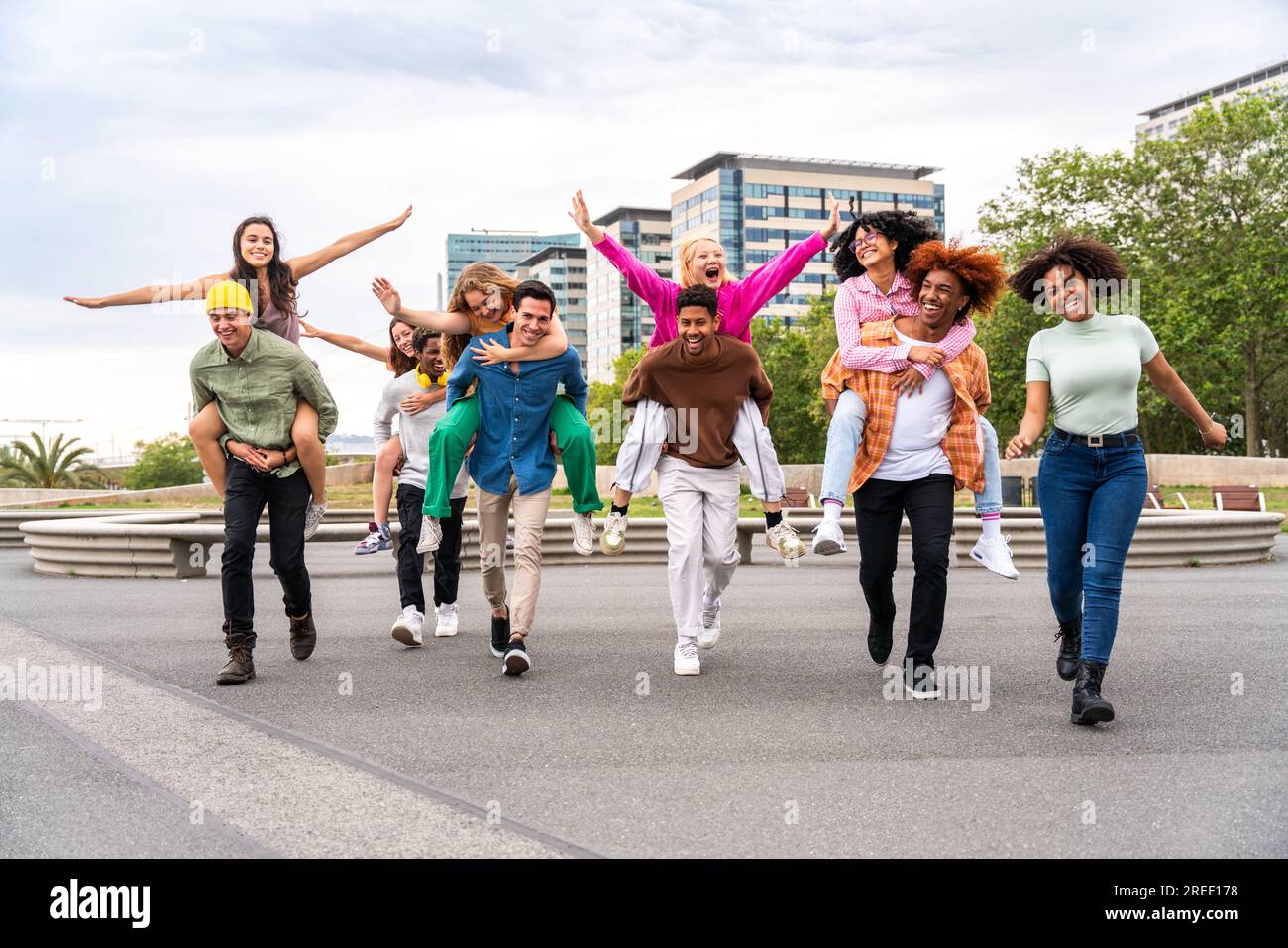 Happy playful multiethnic group of young friends bonding outdoors ...
