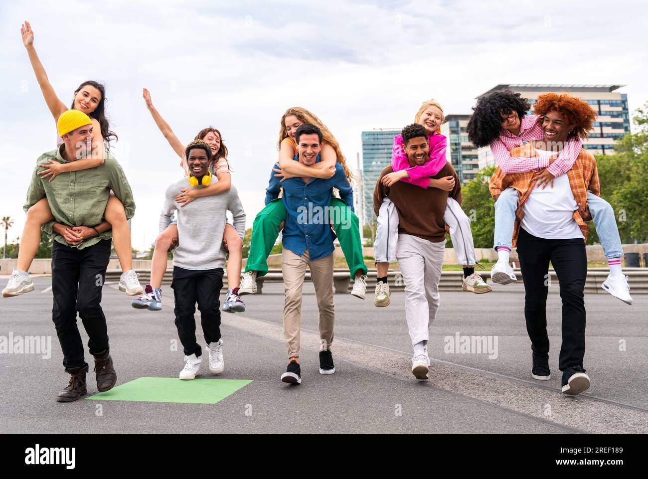 Happy playful multiethnic group of young friends bonding outdoors ...
