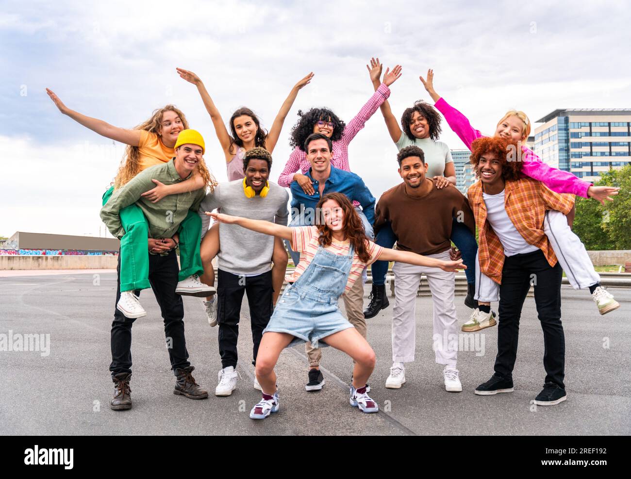 Happy playful multiethnic group of young friends bonding outdoors ...
