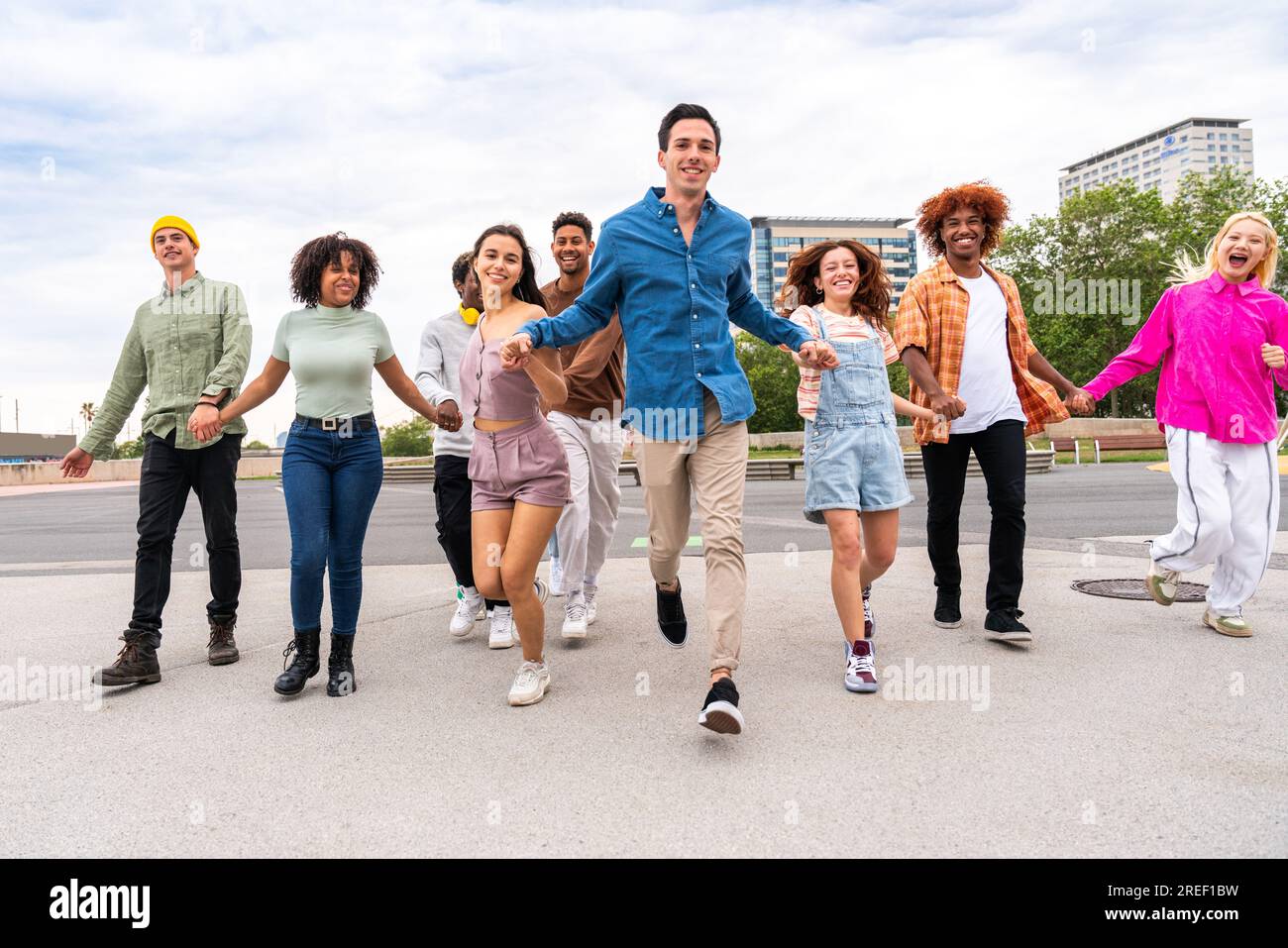 Happy playful multiethnic group of young friends bonding outdoors ...