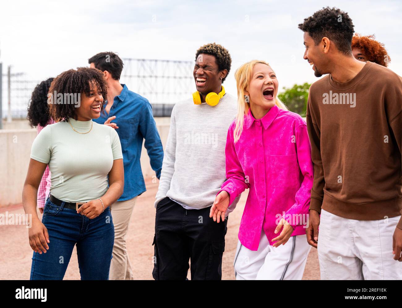 Happy playful multiethnic group of young friends bonding outdoors ...