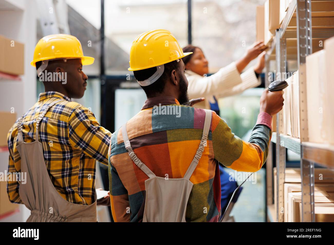 Shipment department workers using barcode scanner in warehouse. African ...