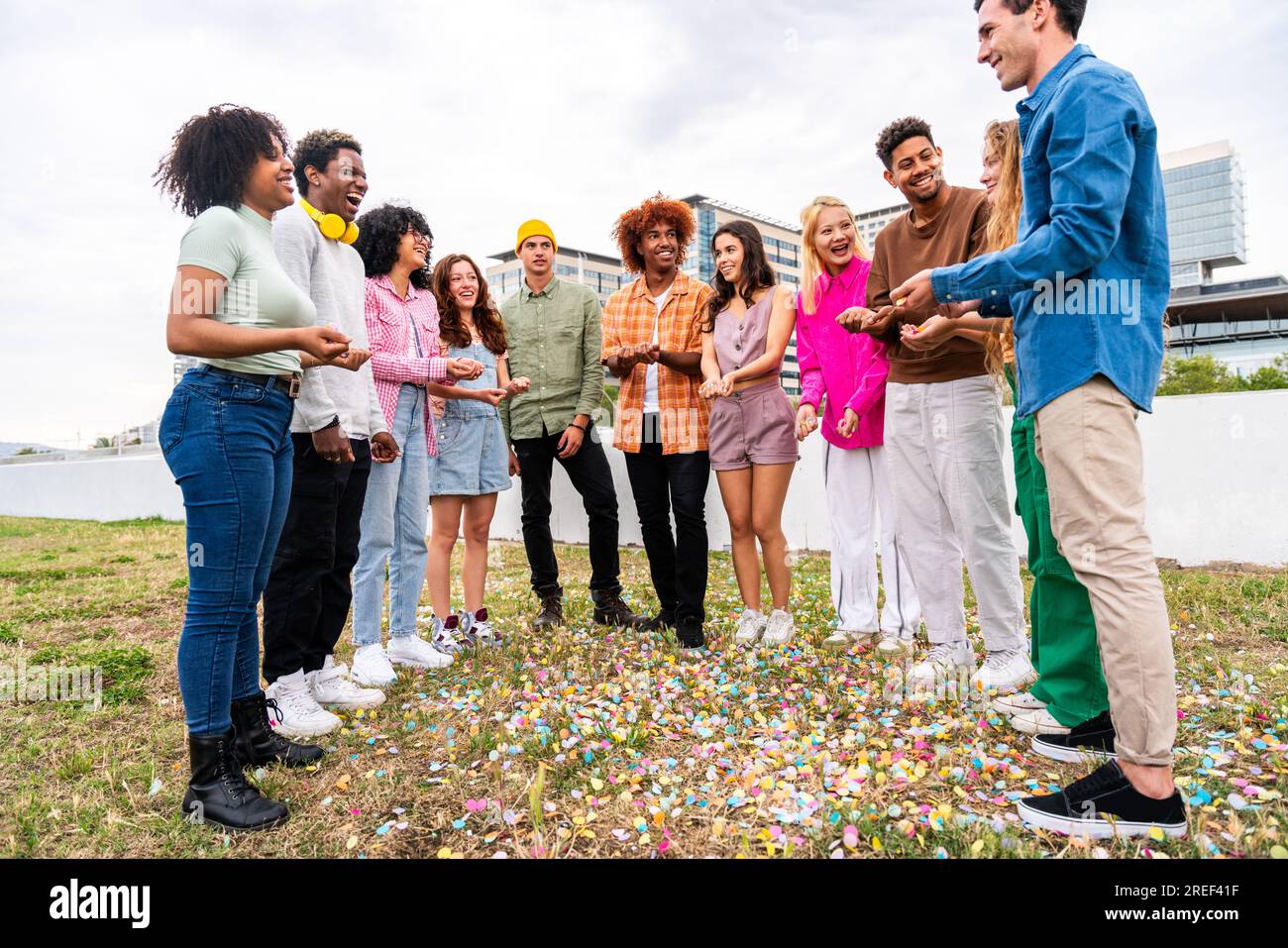 Happy playful multiethnic group of young friends bonding outdoors ...