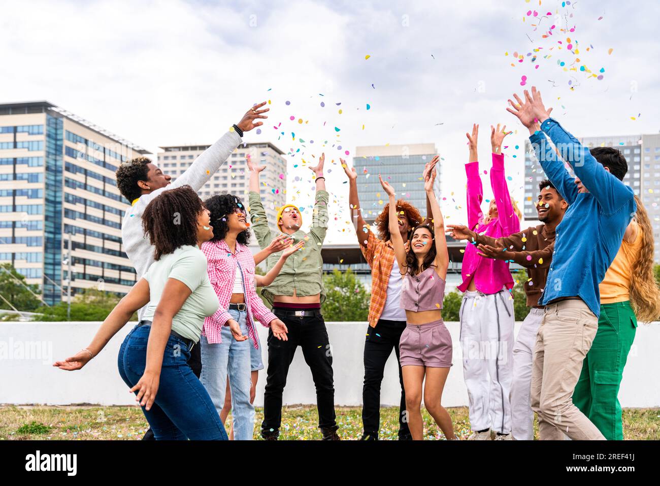 Happy playful multiethnic group of young friends bonding outdoors ...