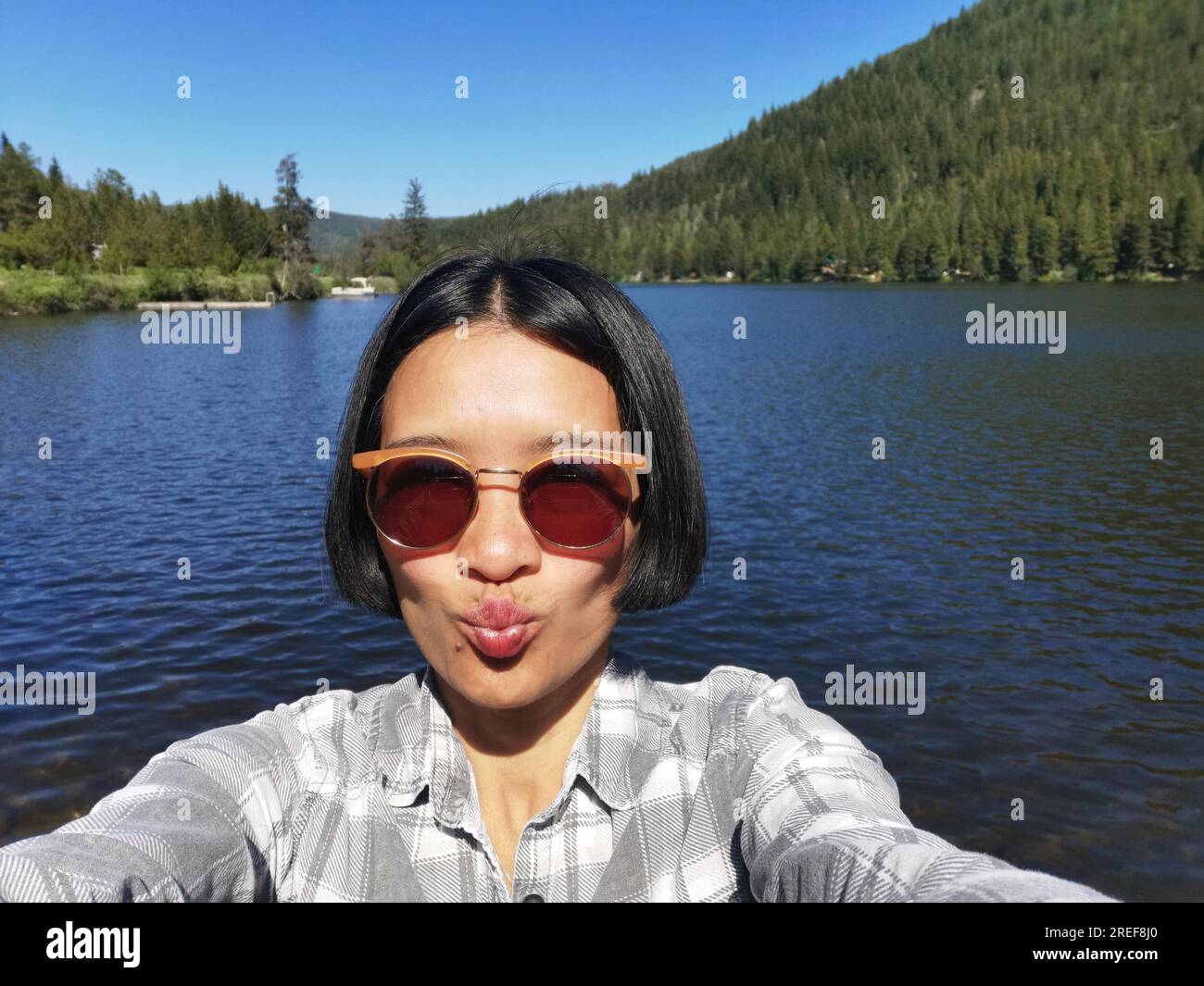 Asian woman taking a selfie at Chain Lake West recreation site, located ...
