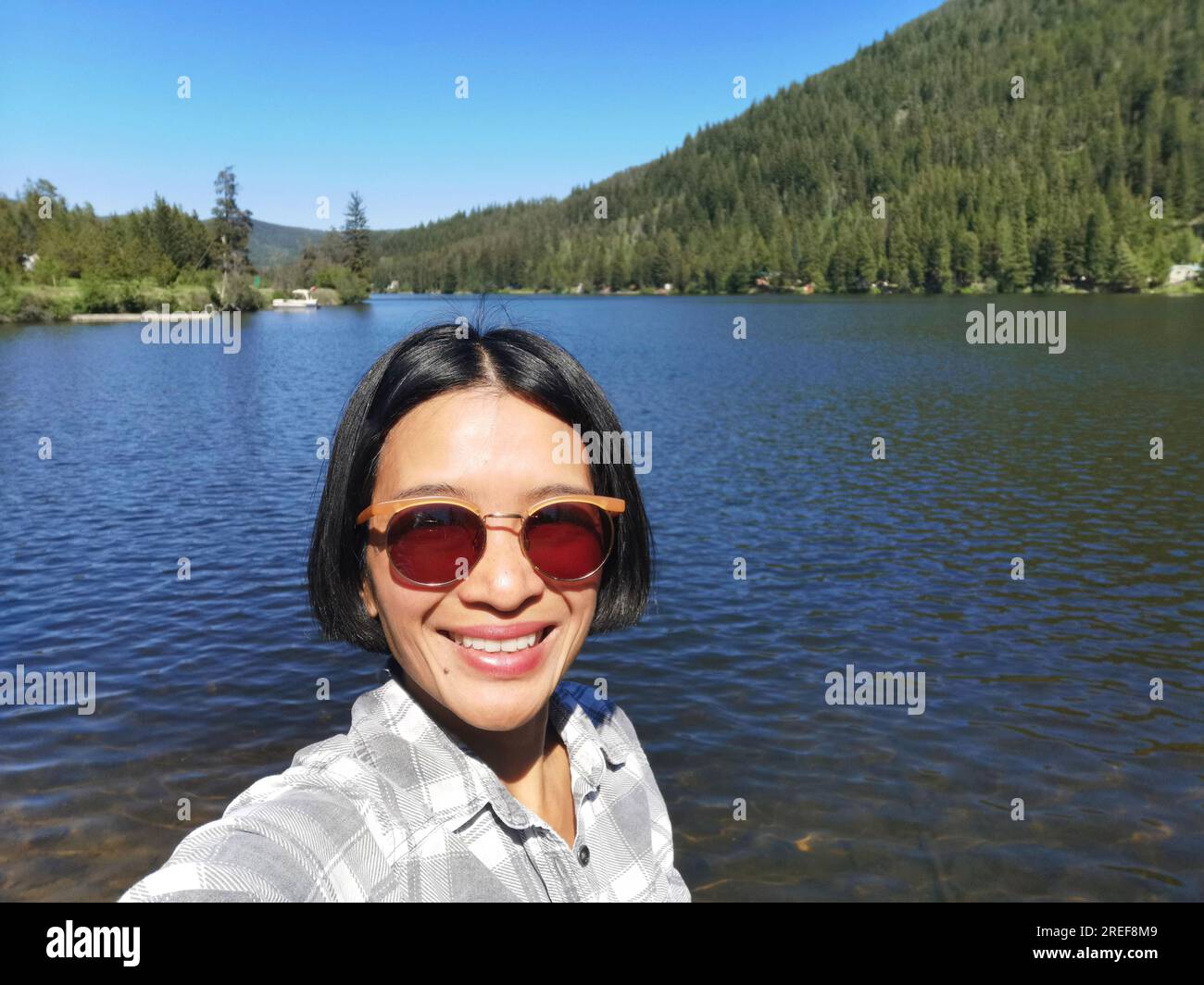 Asian woman taking a selfie at Chain Lake West recreation site, located ...
