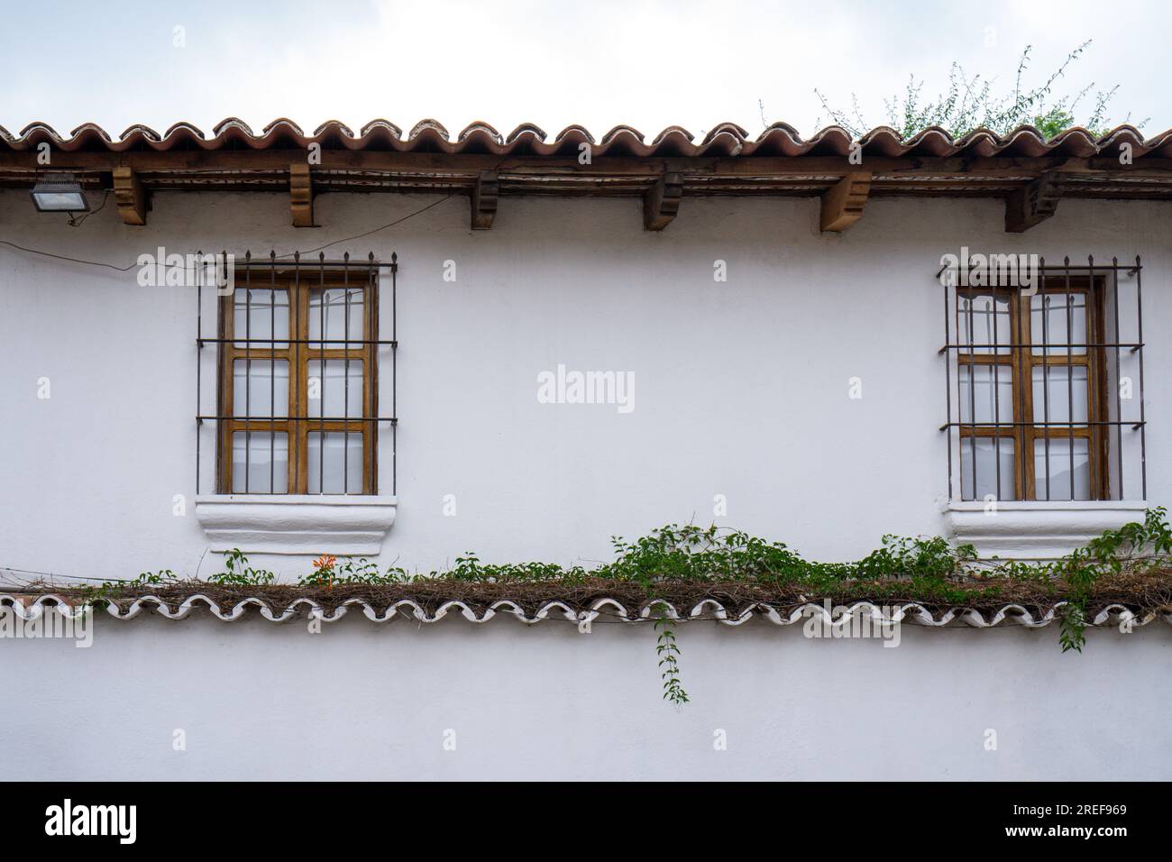 Two symmetric wooden window doors secured with iron bars for safety on ...