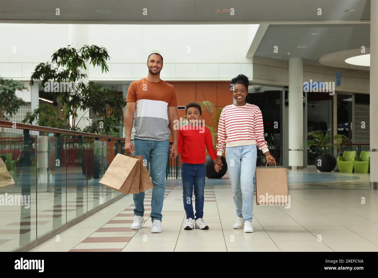 Family shopping. Happy parents and son with purchases in mall Stock ...