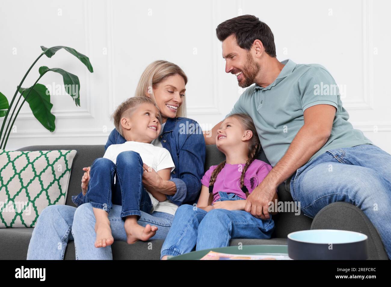 Happy family having fun together on sofa at home Stock Photo - Alamy