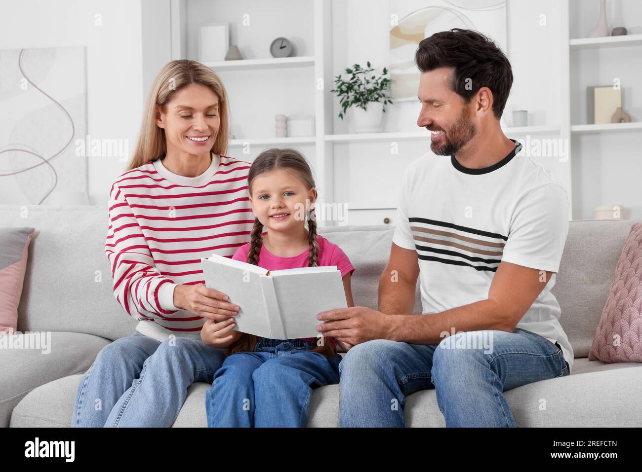Happy family reading book hi-res stock photography and images - Alamy