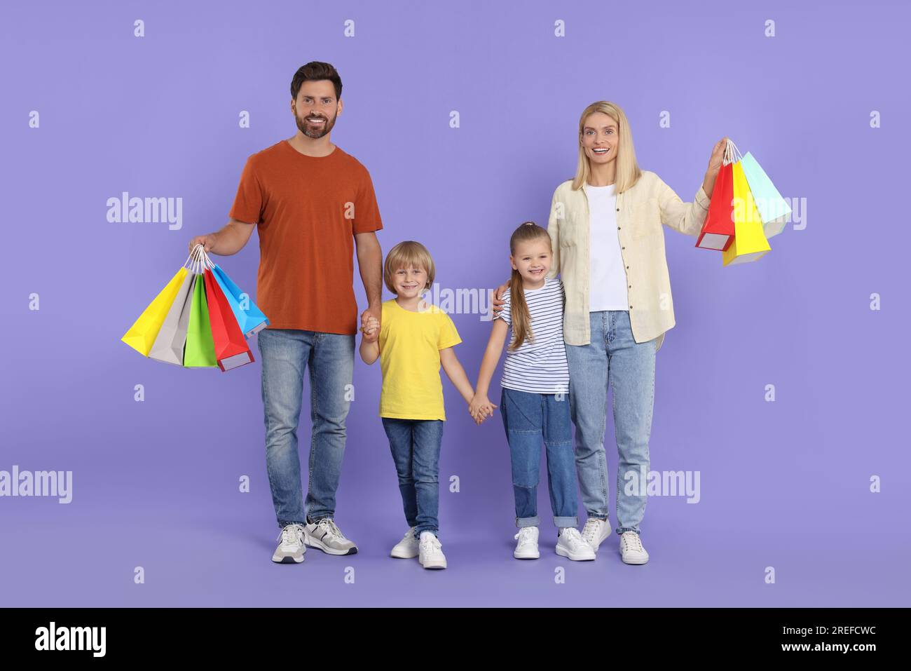 Family shopping. Happy parents and children with many colorful bags on ...