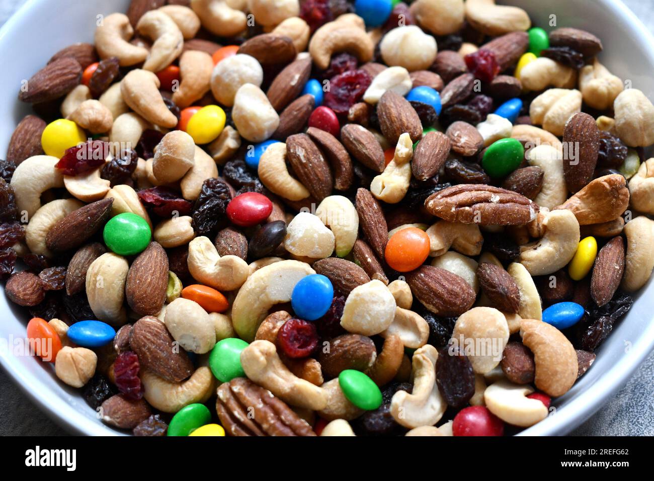 Colorful trail mix in a white bowl Stock Photo - Alamy