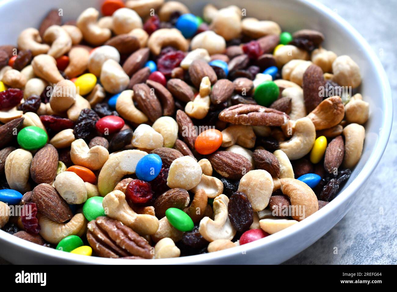 Colorful trail mix in a white bowl Stock Photo - Alamy