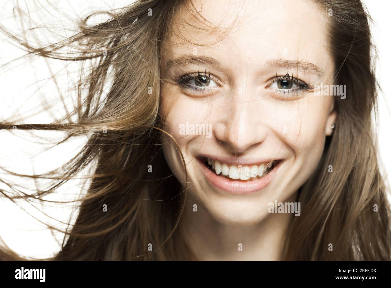 brunette girl with flowing hair in the air studio portrait against ...