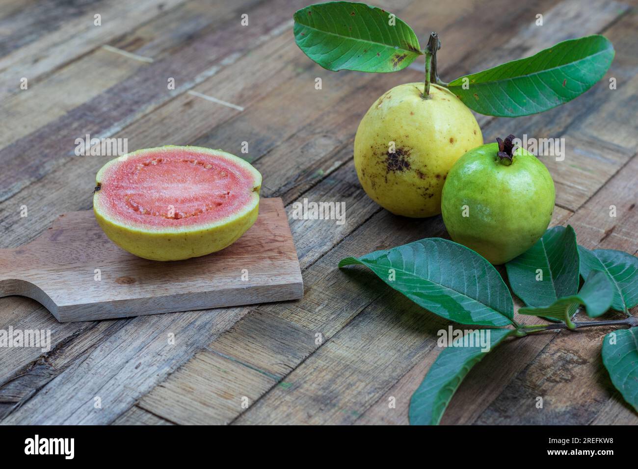 Fresh red guava with green leaves on wooden background. Texture of wood ...