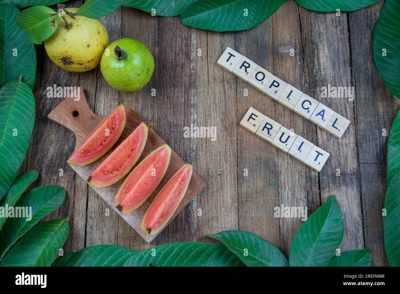 Fresh guava with green leaves on wooden background. Texture of wood and ...