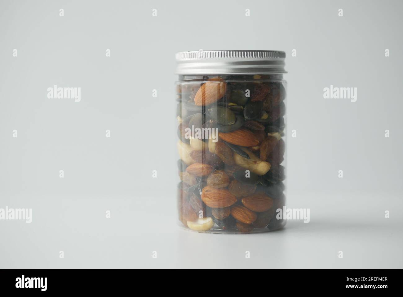 close up of many mixed nuts in a container on white background Stock ...