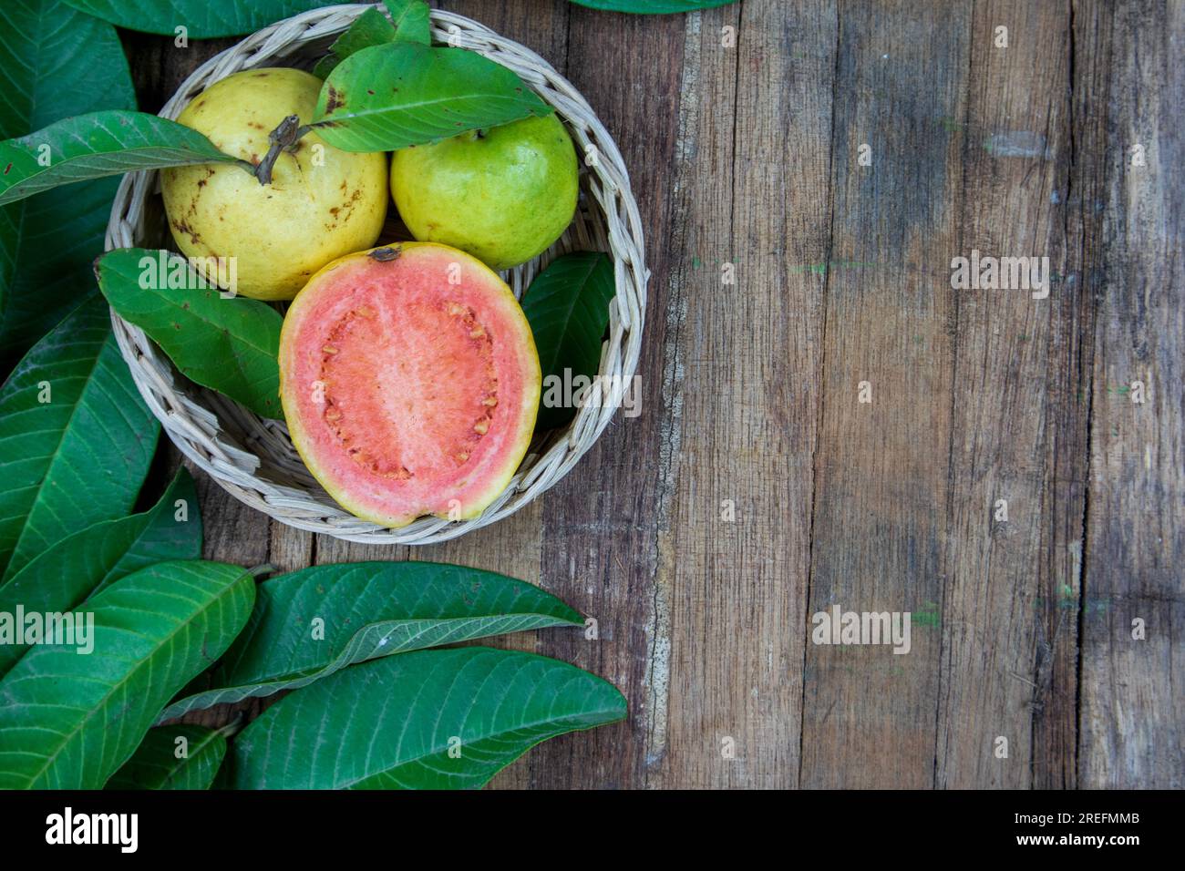 Fresh guava with green leaves on wooden background. Texture of wood and ...