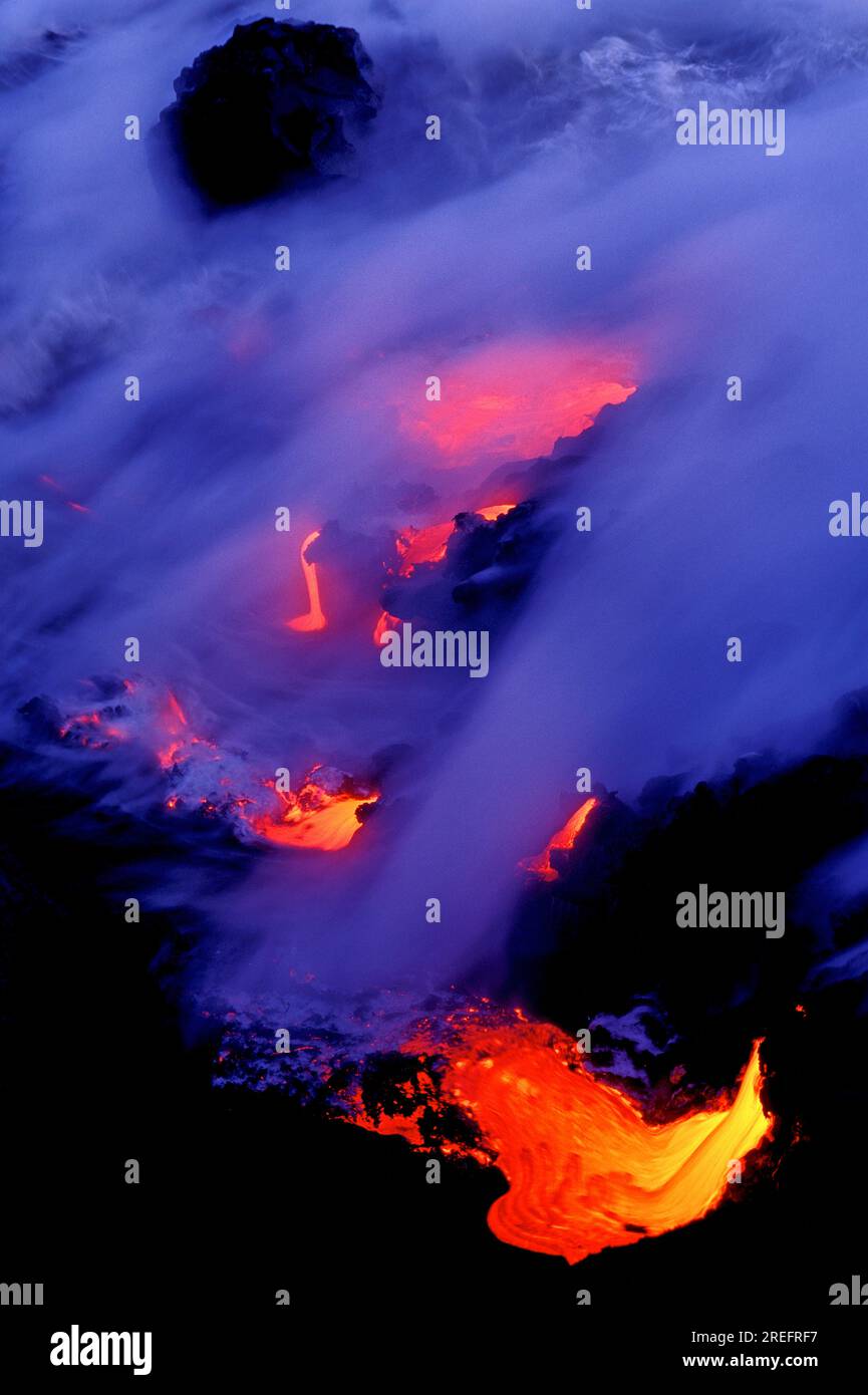 Fiery lava flows into the ocean creating clouds of steam at Volcanoes ...
