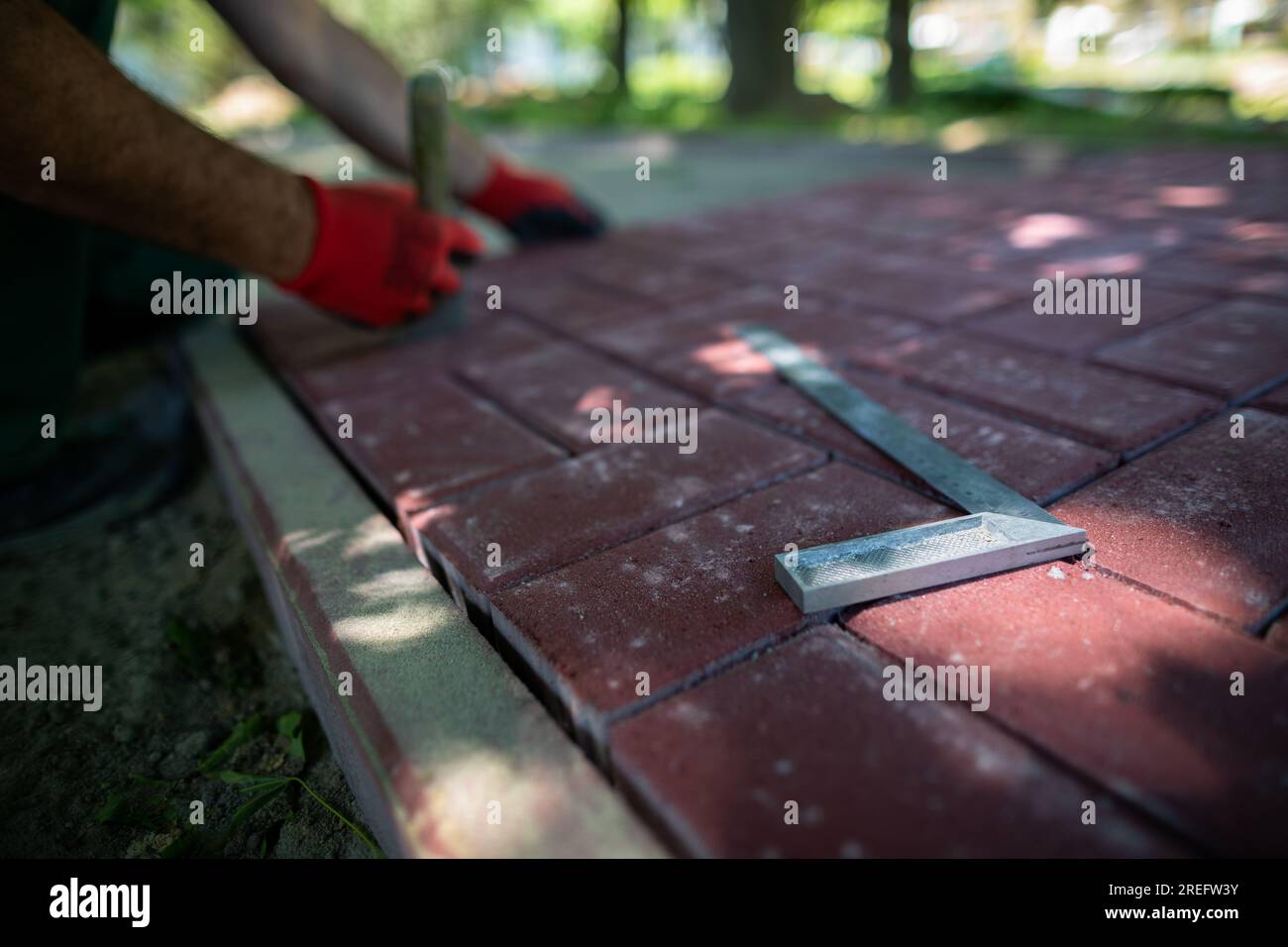 The protractor lies on the paving stones and the worker lays the ...