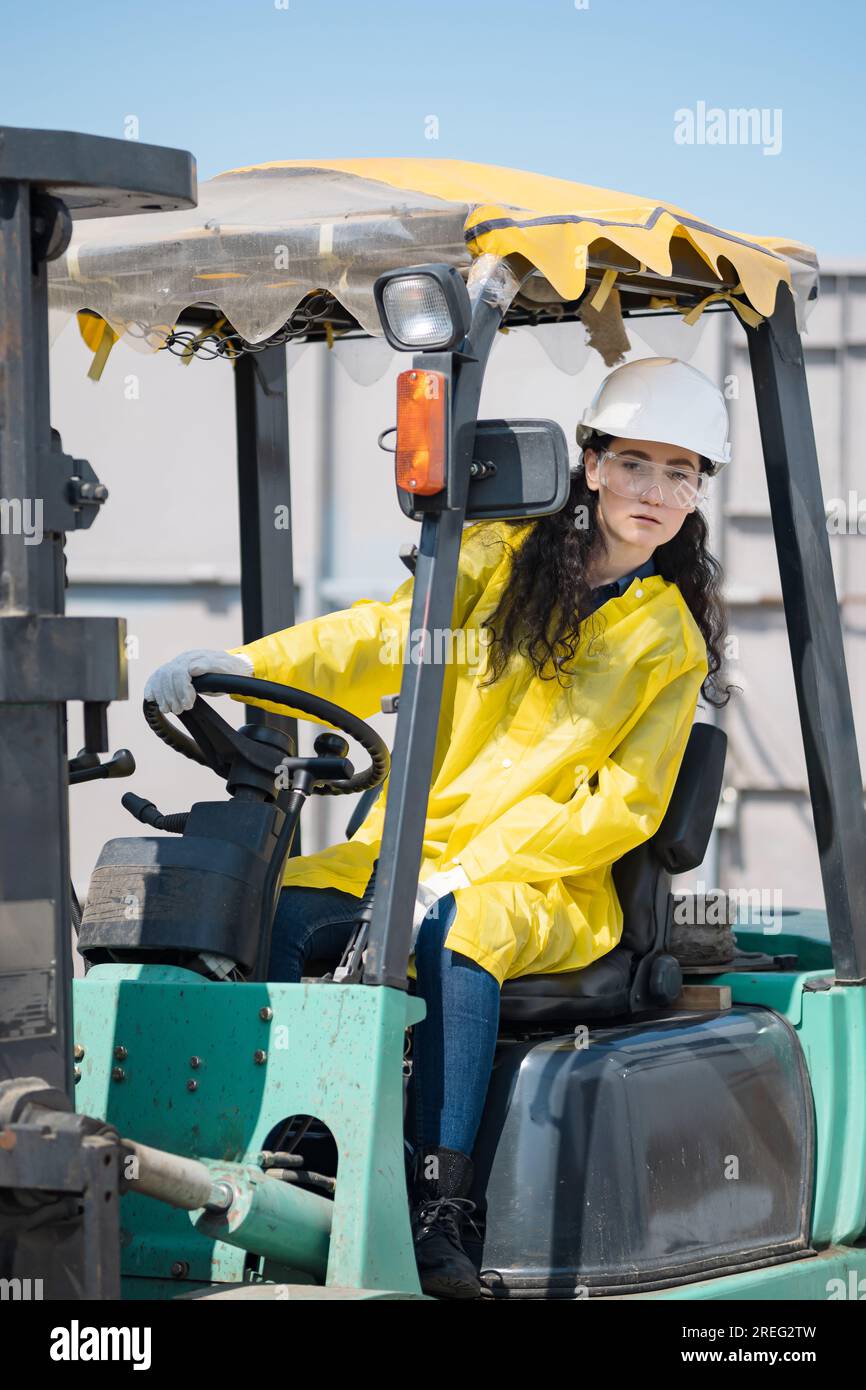 Dark-haired lady worker operating excavator sorting waste Stock Photo ...