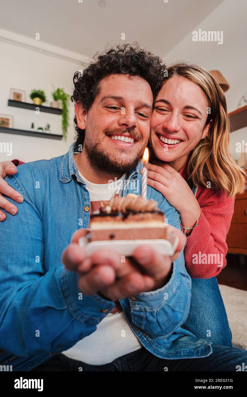 Vertical portrait of happy young couple celebrating a birthday with a ...