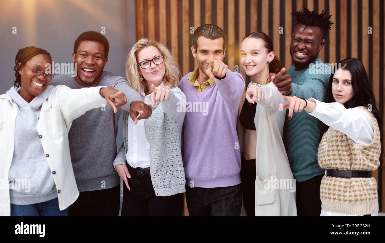 Group of cheerful young people standing close to each other and ...