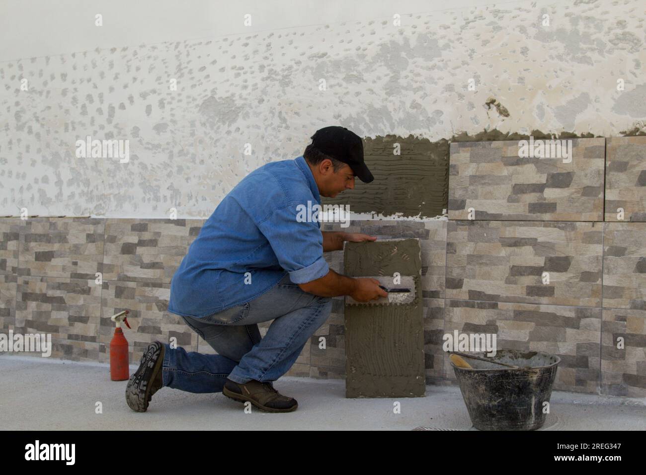 Image of a handyman tiler who with a spatula spreads the glue for ...