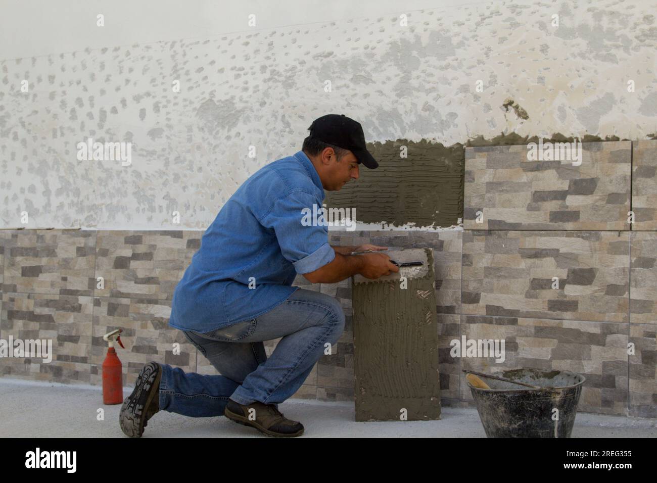 Image of a handyman tiler who with a spatula spreads the glue for ...
