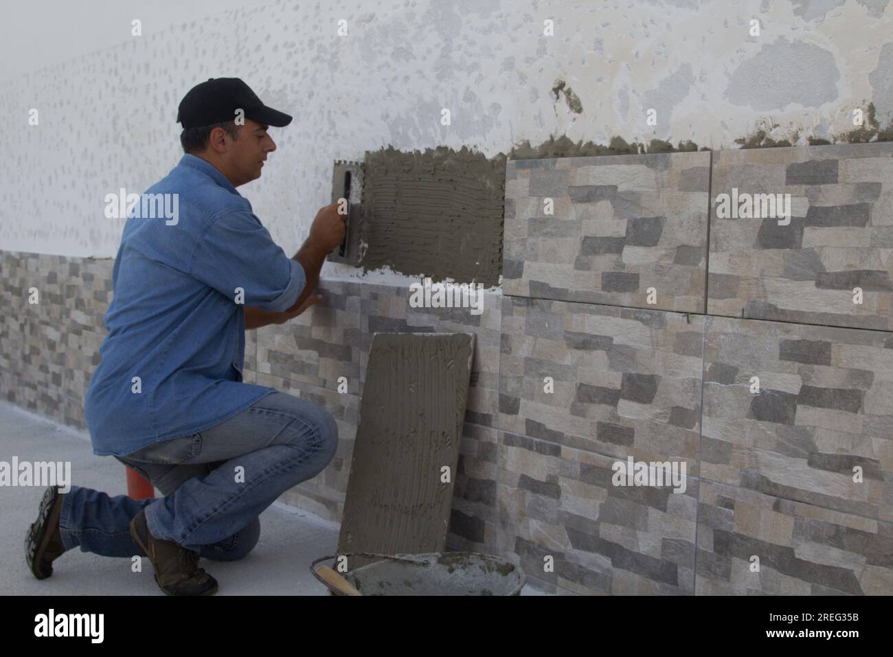 Image of a handyman tiler who with a spatula spreads the glue for ...