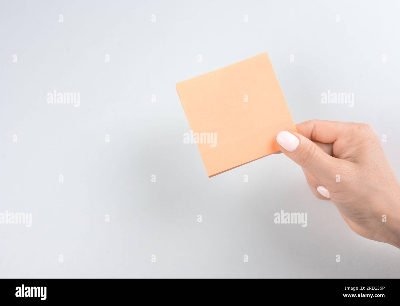 Blank sheet for notes. female hand holding note paper mockup for making ...