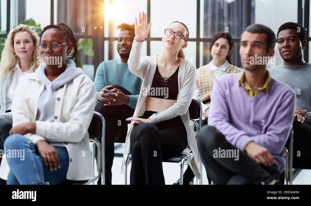 Woman raised up hands and arms in seminar class room to agree with ...