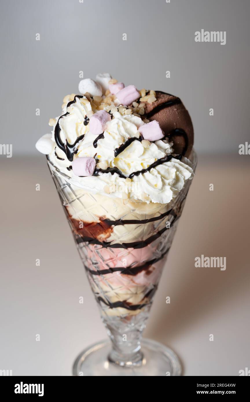 Banana split sundae served in a tall sundae glass with 3 scoops of ice ...