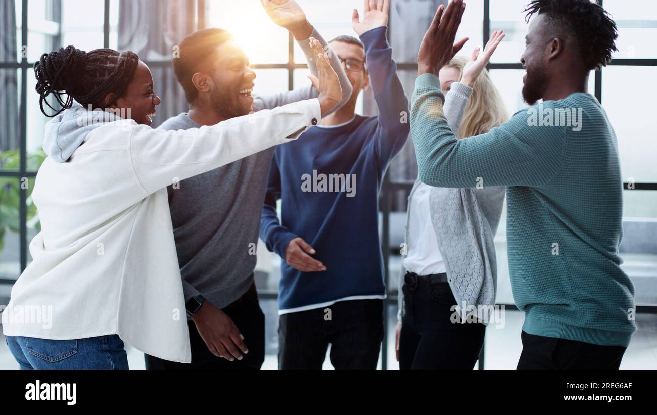 Group of happy colleagues feel motivated giving high five Stock Photo ...