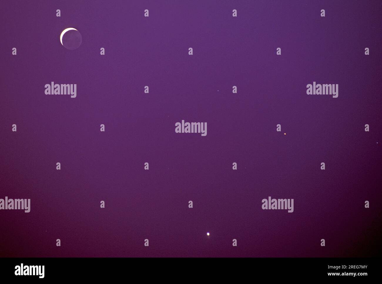 Eclipse of the moon against a purple sky showing a moonshadow and stars ...