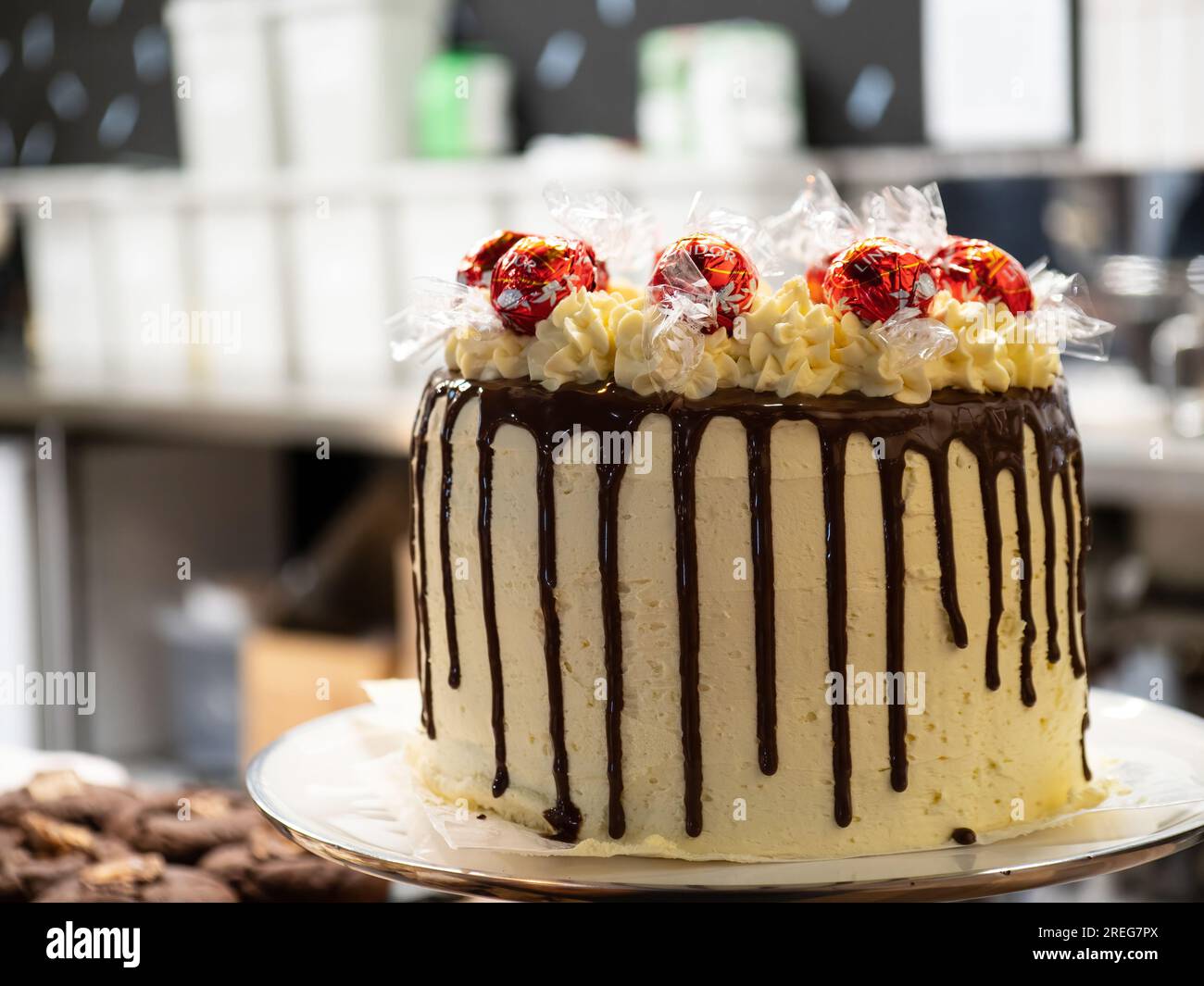 Tall white cake with chocolate drizzle topping Stock Photo - Alamy