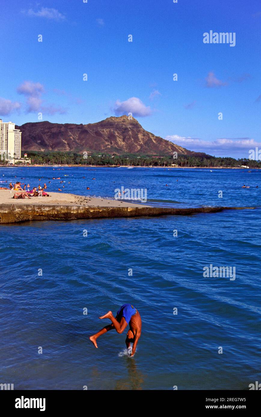 A young man jumps into the ocean from an area known as Kapahulu Groin ...