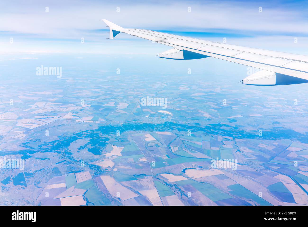Aerial view from airplane window above green ground. View from the ...