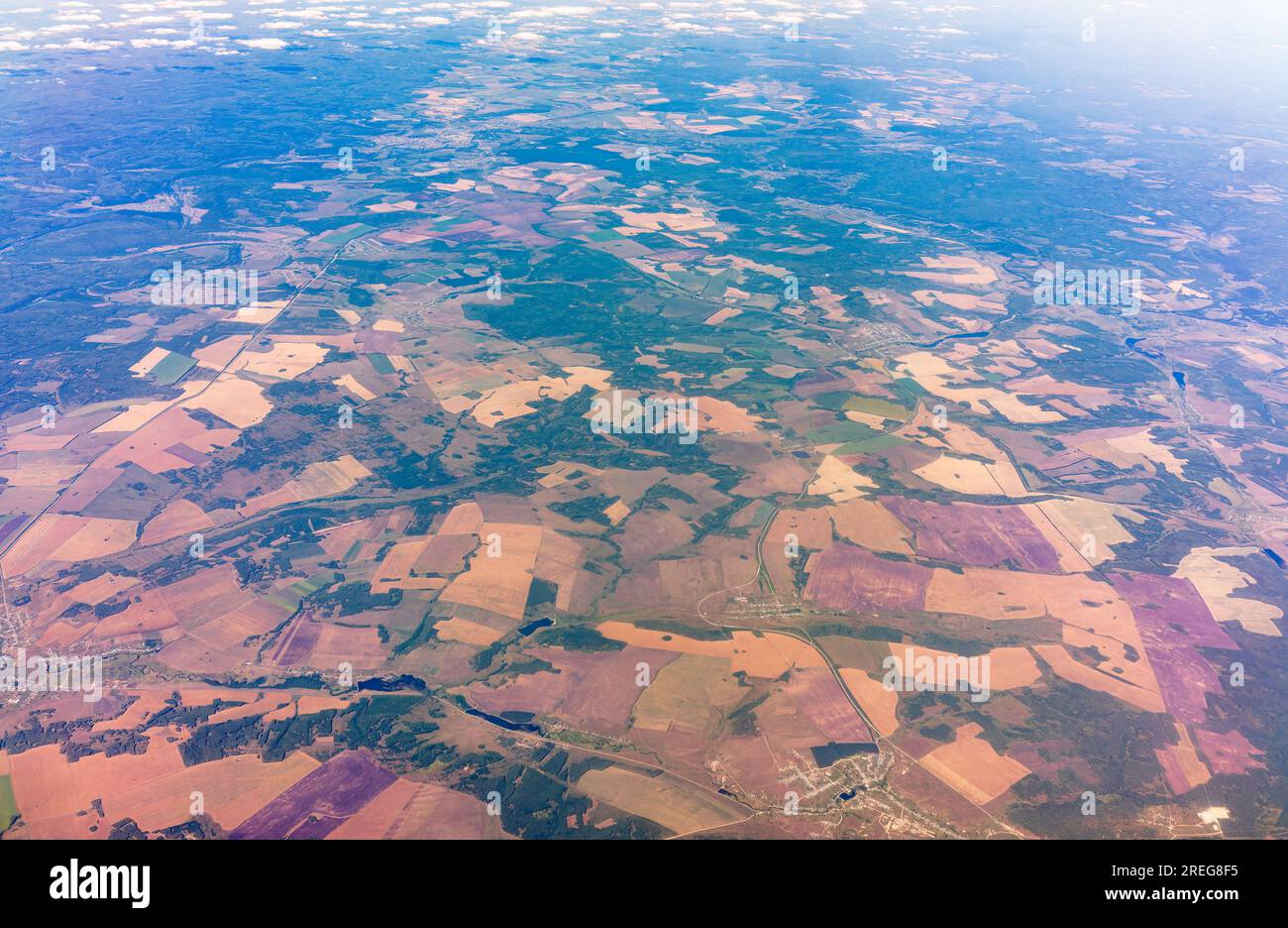 Aerial view from airplane window above green ground. View from the ...