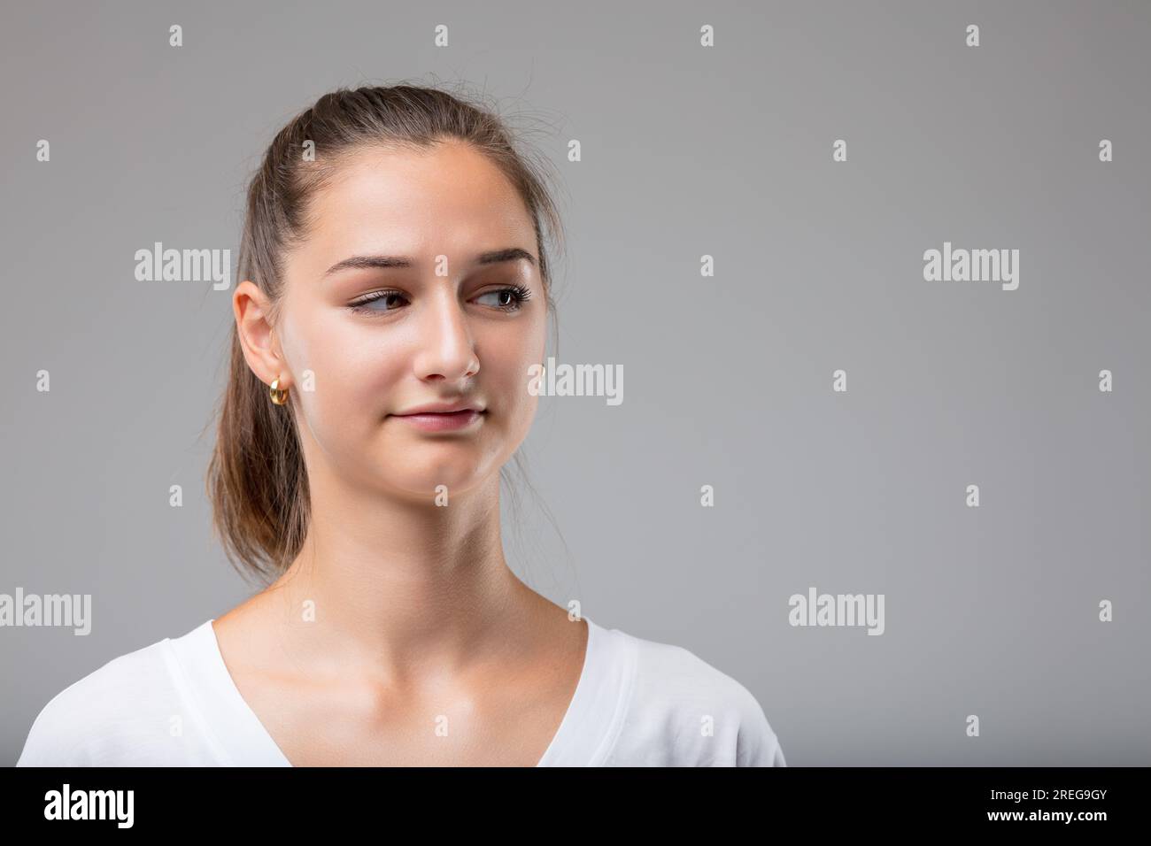 Expression of obvious disgust at something by a young woman in a white ...