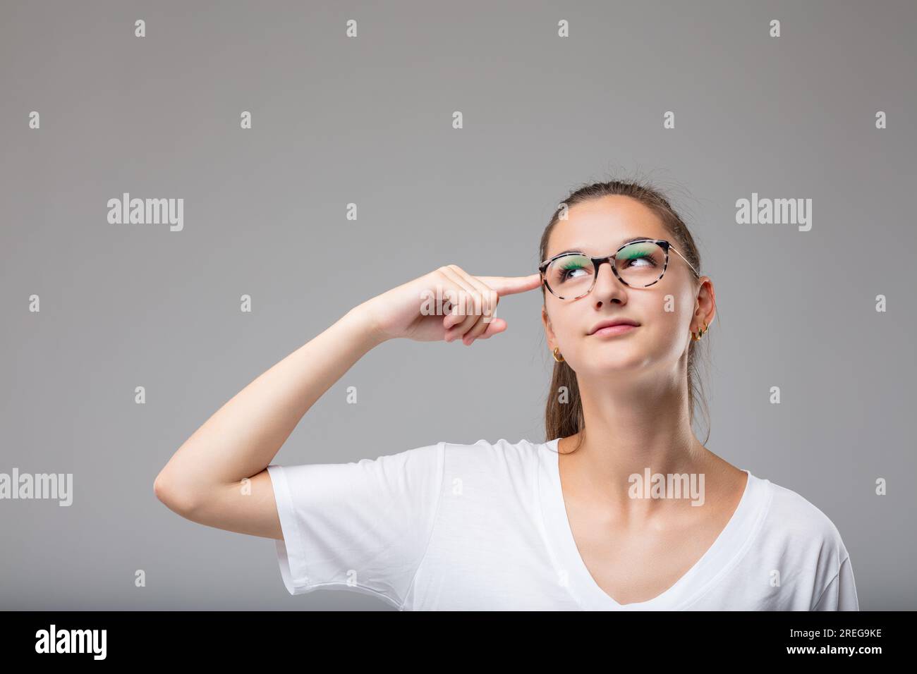 Deep in thought, a young woman's face reveals her eureka moment, as she ...