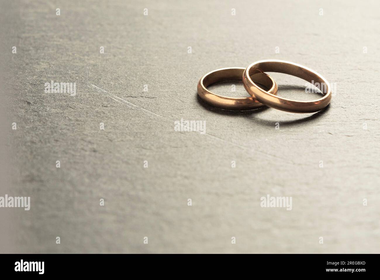 Wedding rings leaning against a rock surface, shallow depth of field ...